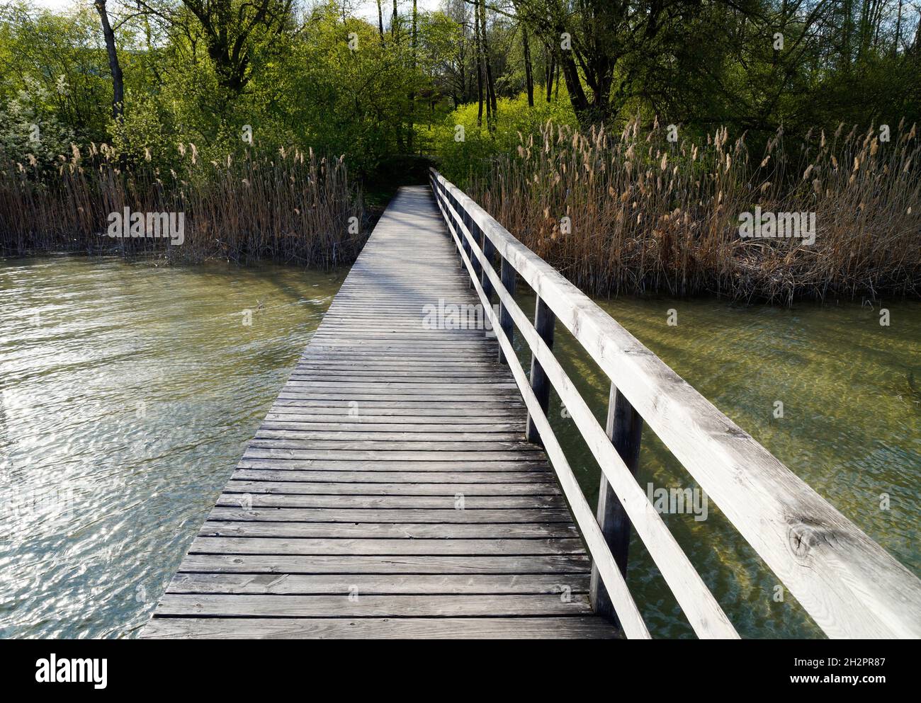 a long wooden pier on lake Ammersee in the scenic German fishing ...