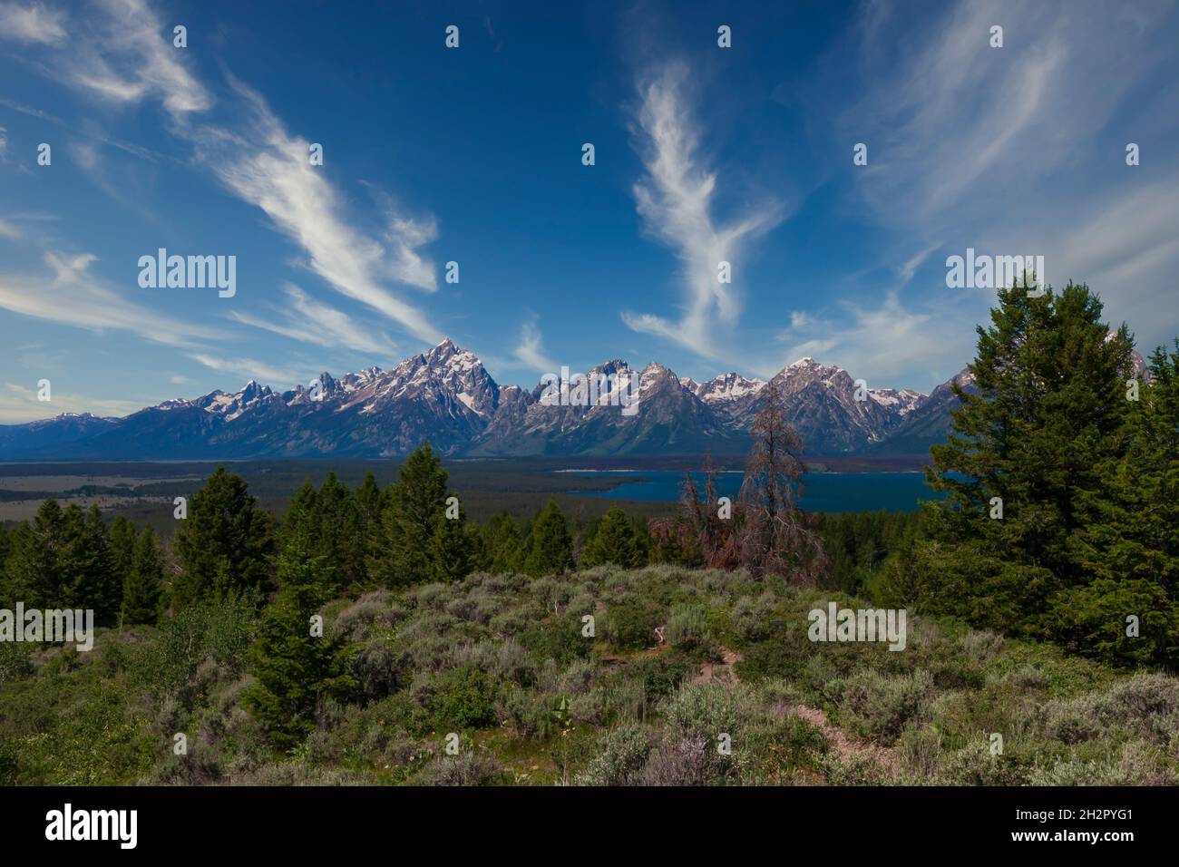 Photograph of a large mountain range in the distance with snow caps on ...