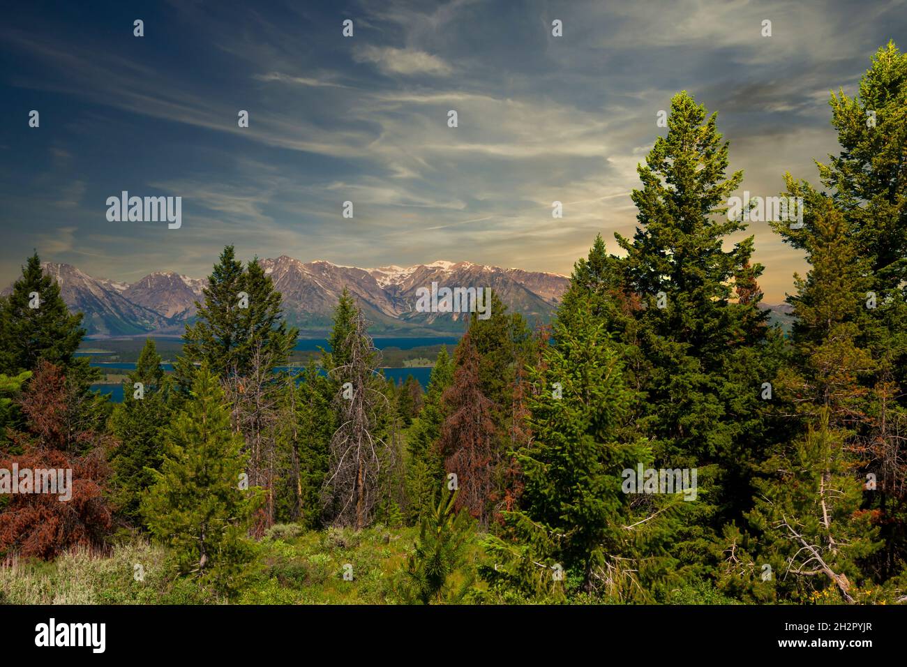 Photograph of a large mountain range in the distance with snow caps on ...