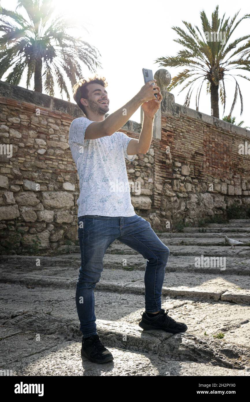 Vertical shot of a Spanish Caucasian male taking a selfie of himself ...