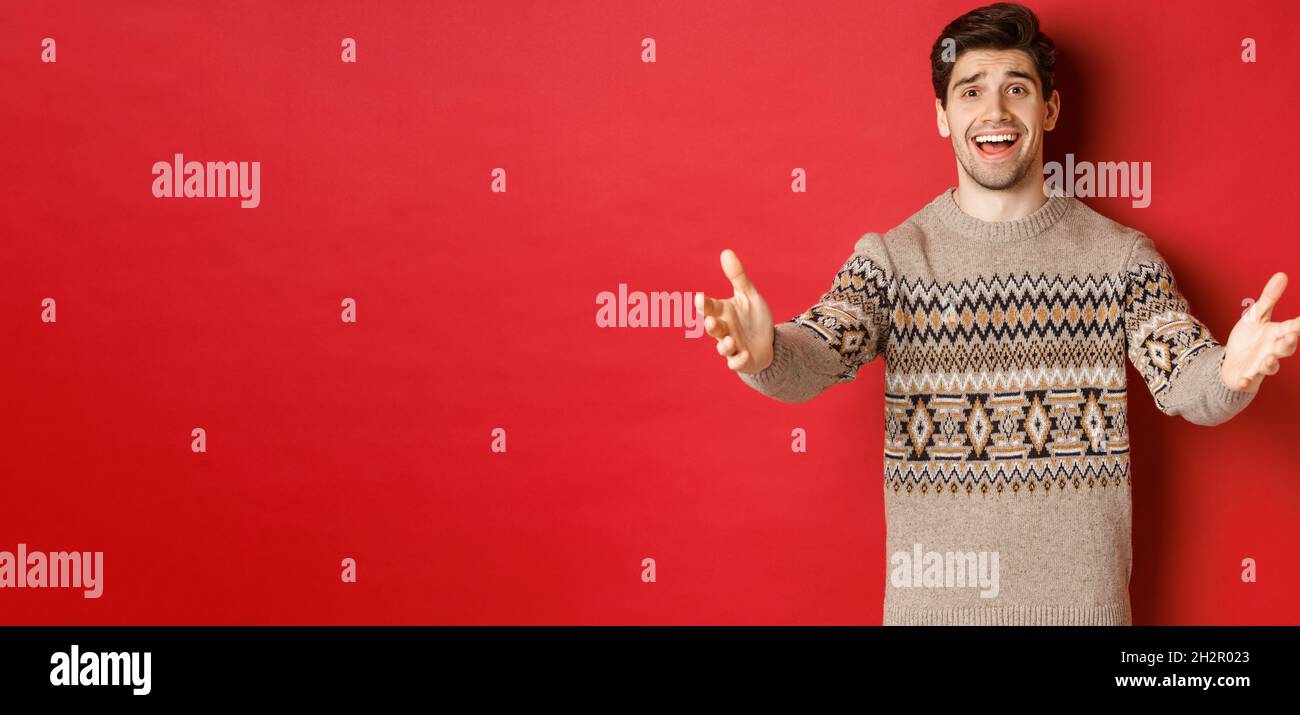 Image of happy and flattered handsome guy in christmas sweater ...