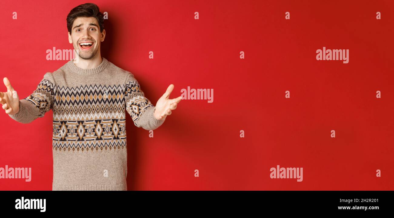 Image of happy and flattered handsome guy in christmas sweater ...