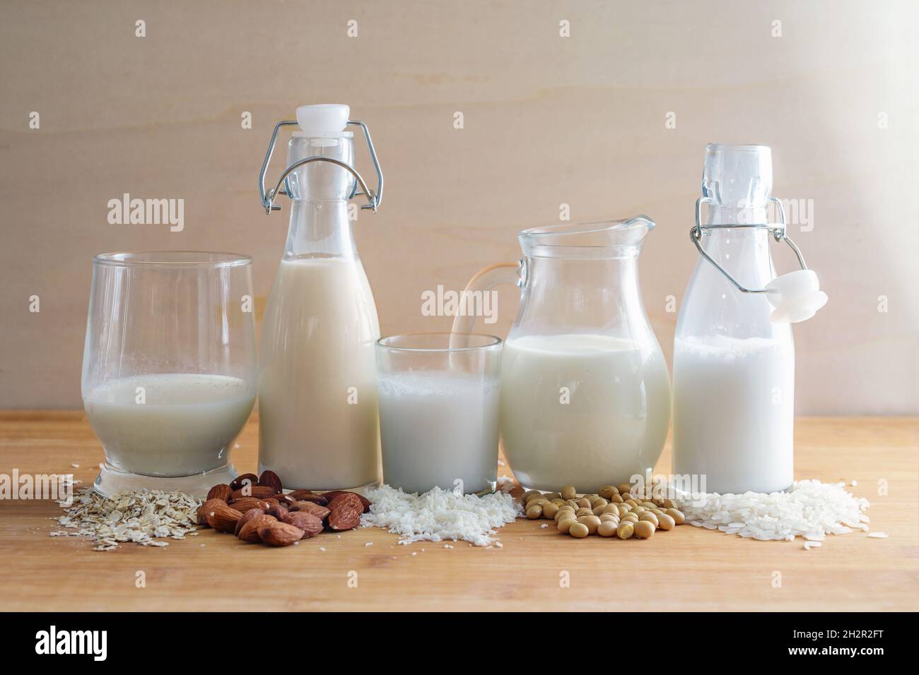 Vegan milk variations made from cereals and nuts in glasses and bottles ...