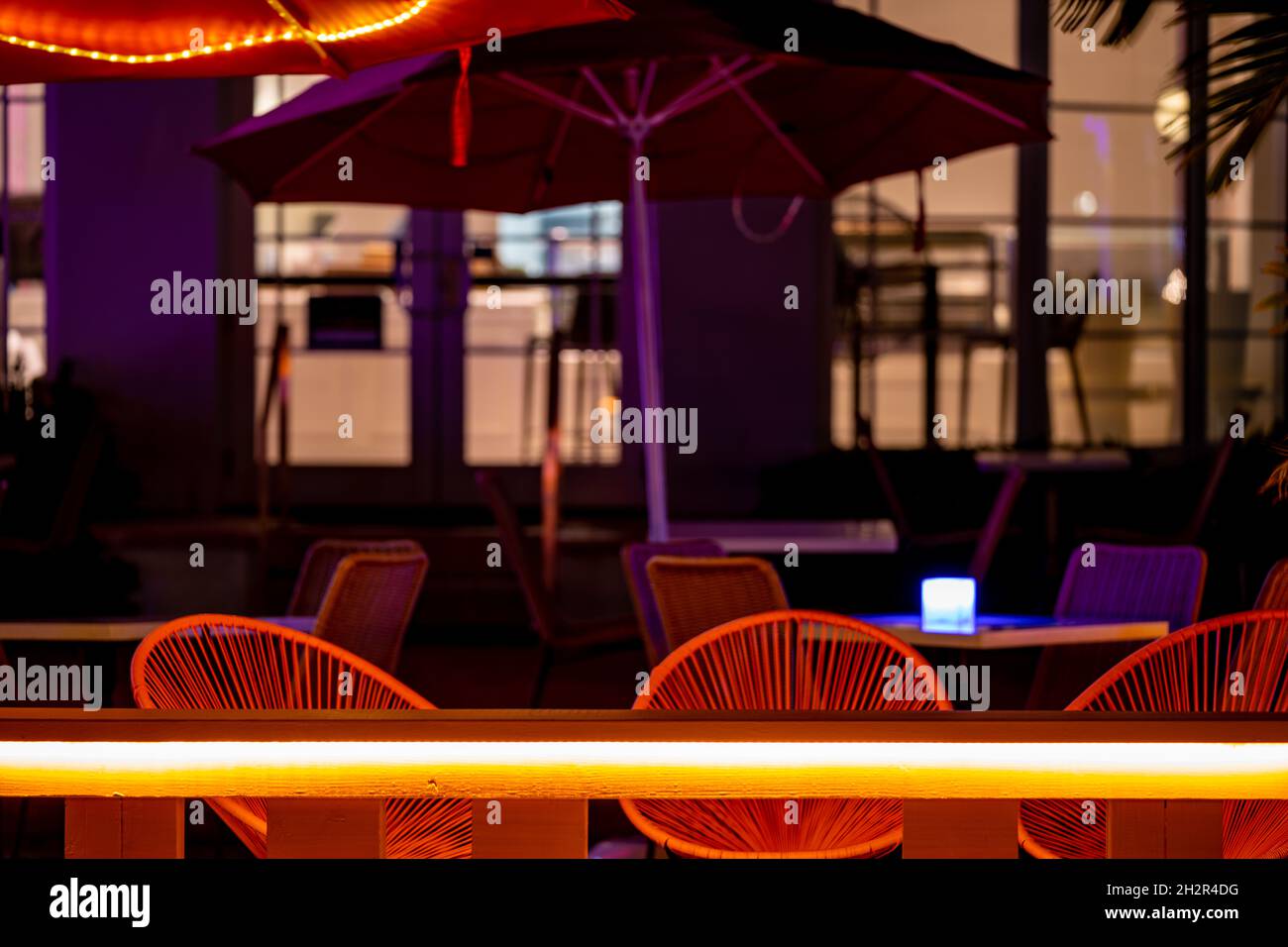 Restaurant at night with chairs and neon lights Stock Photo - Alamy