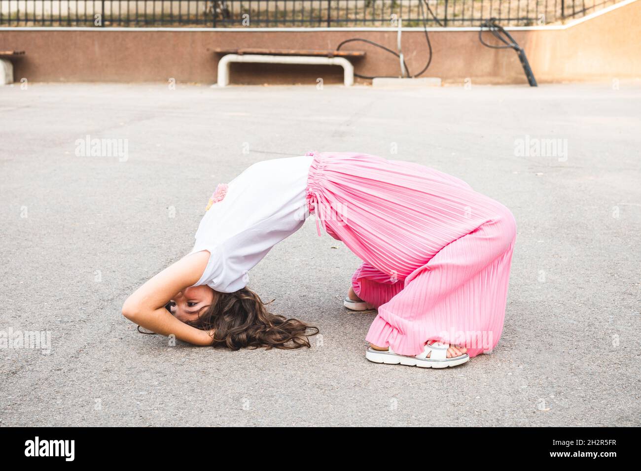 Little brunette girl making bridge pose, playing around Stock Photo - Alamy