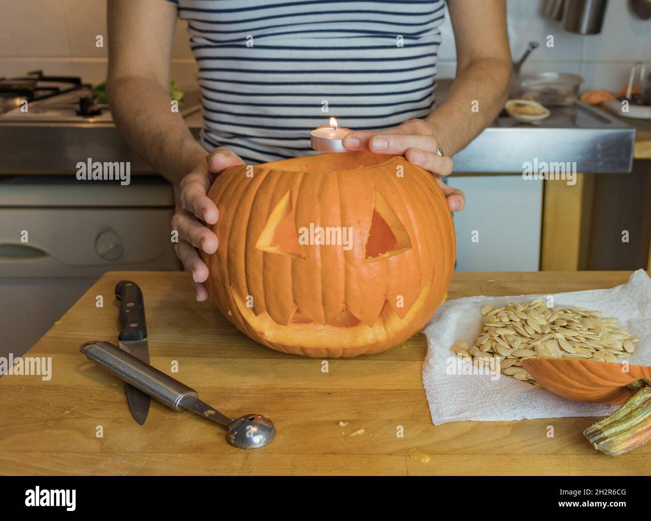 Human hand inserting candle in pumpkin for Halloween Stock Photo - Alamy