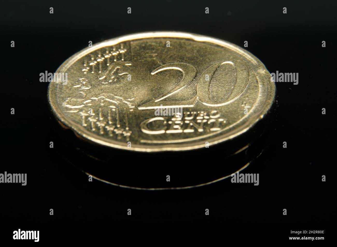 Closeup shot of a 20 euro cent coin isolated on a black background ...