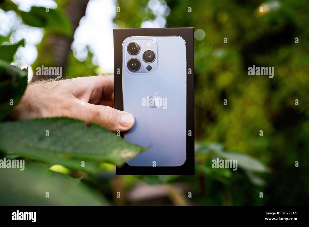 Male hand holding the redesigned package box of the new Apple Computers ...