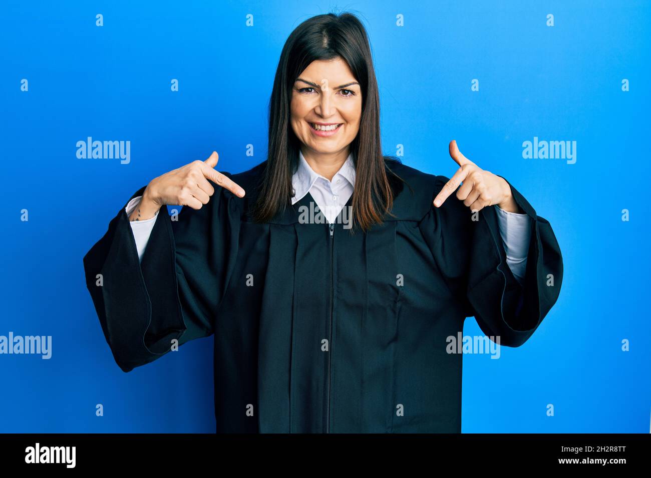 Young hispanic woman wearing judge uniform looking confident with smile ...