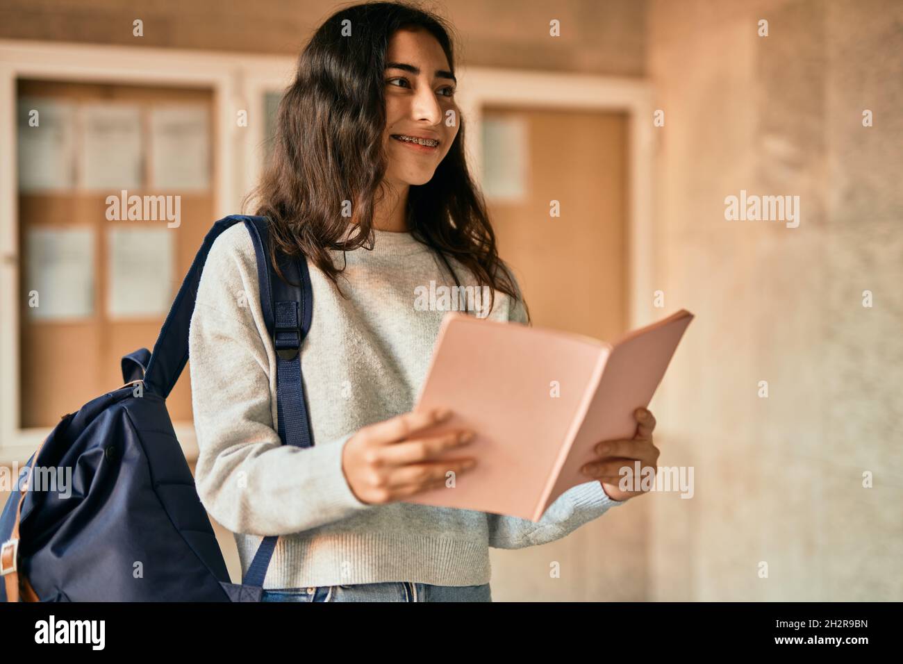 Young middle east student girl smiling happy reading book at the city ...