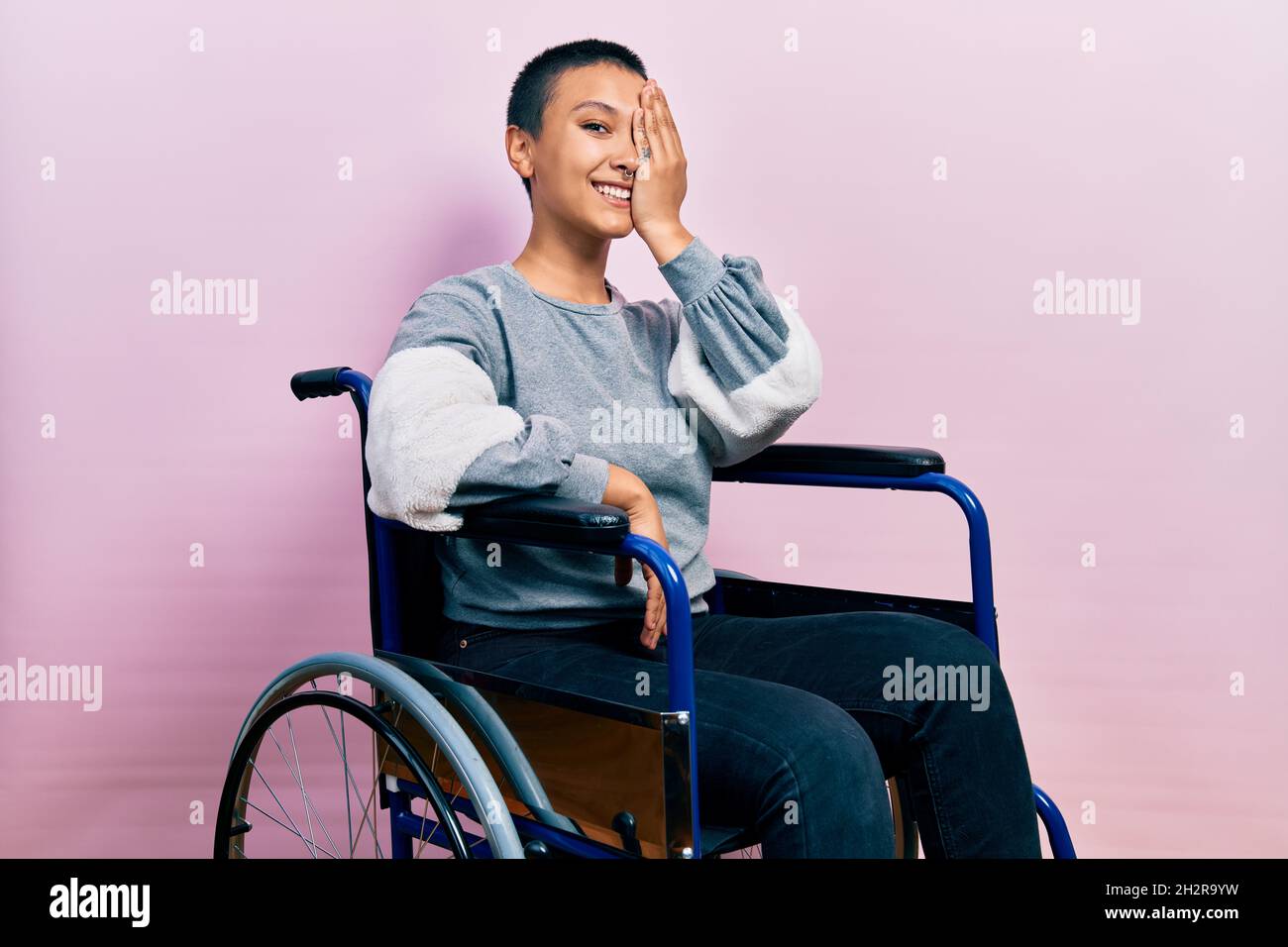 Beautiful hispanic woman with short hair sitting on wheelchair covering ...