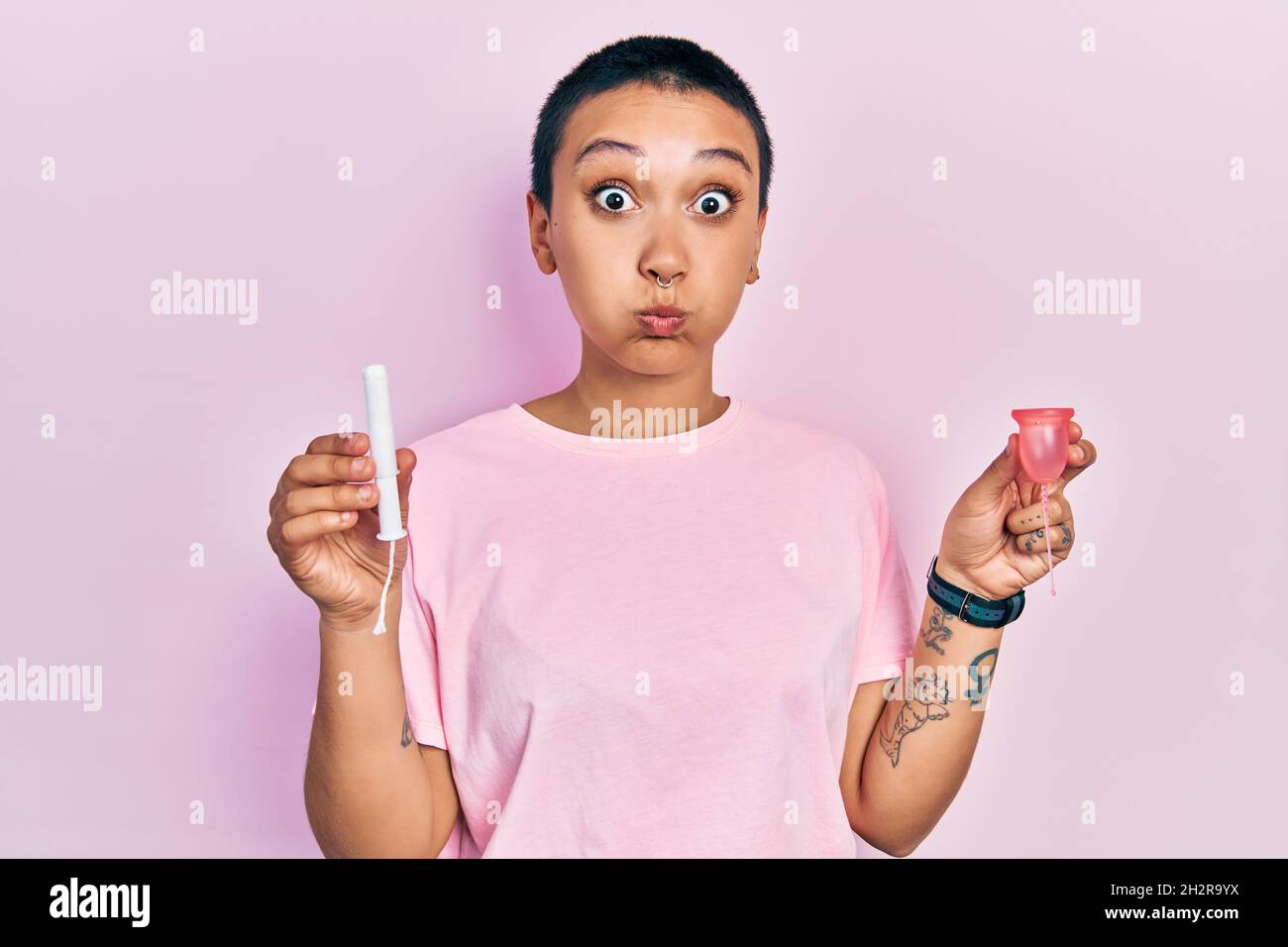 Beautiful hispanic woman with short hair holding menstrual cup and ...
