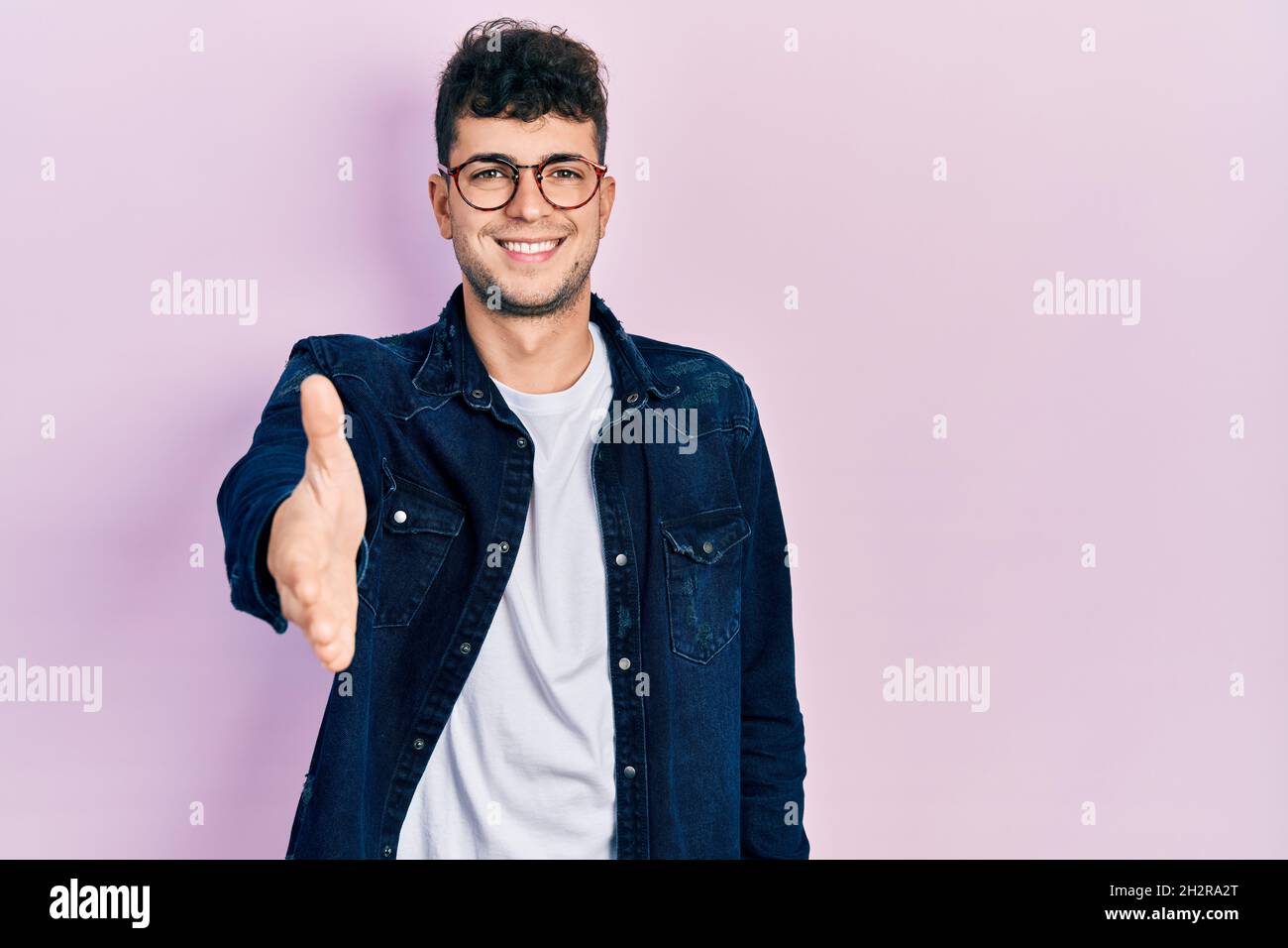 Young hispanic man wearing casual clothes and glasses smiling friendly ...
