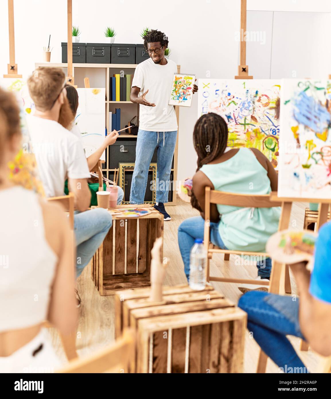 Group of people smiling happy drawing in paint class at art studio ...