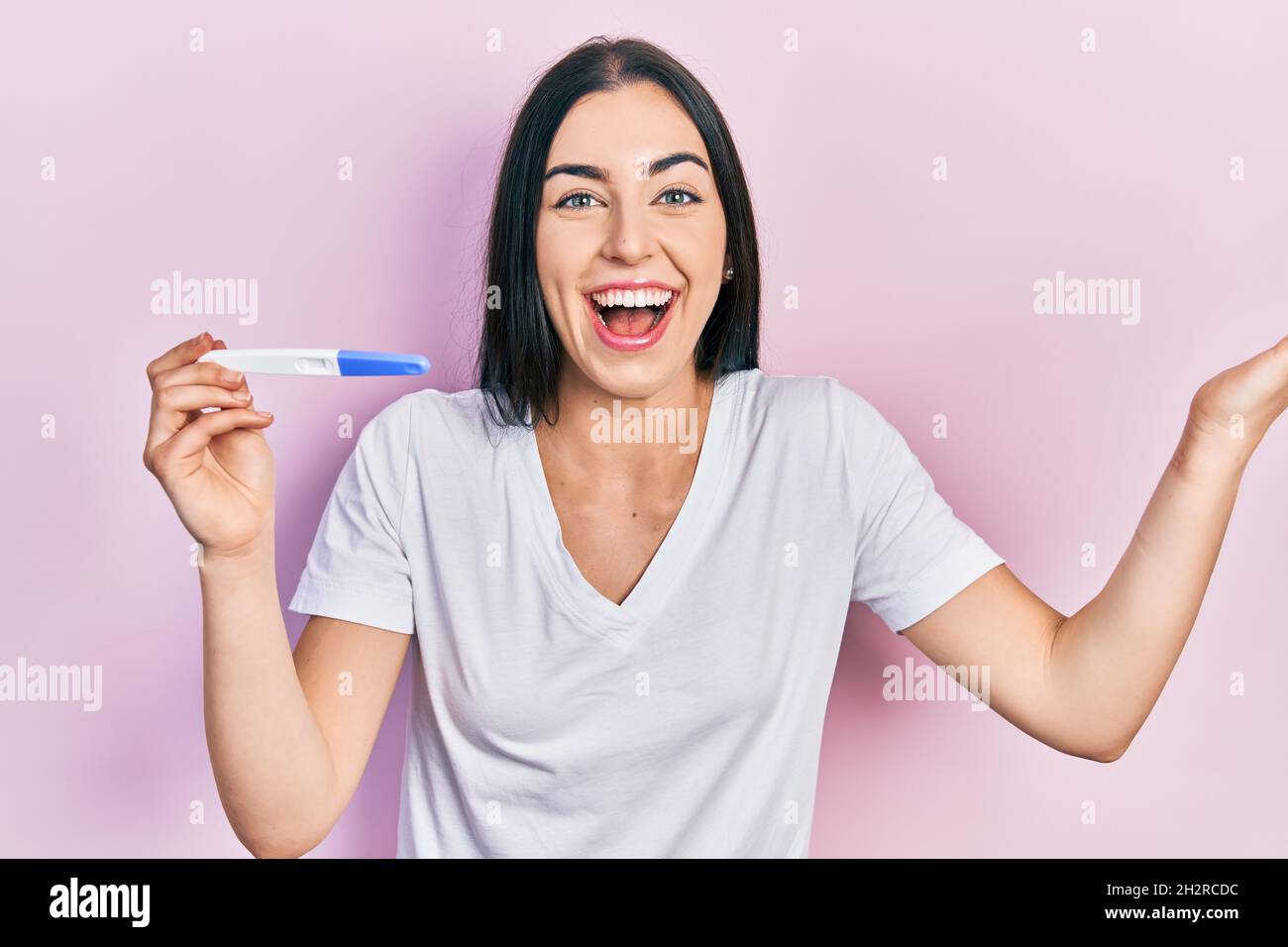 Beautiful woman with blue eyes holding pregnancy test result ...