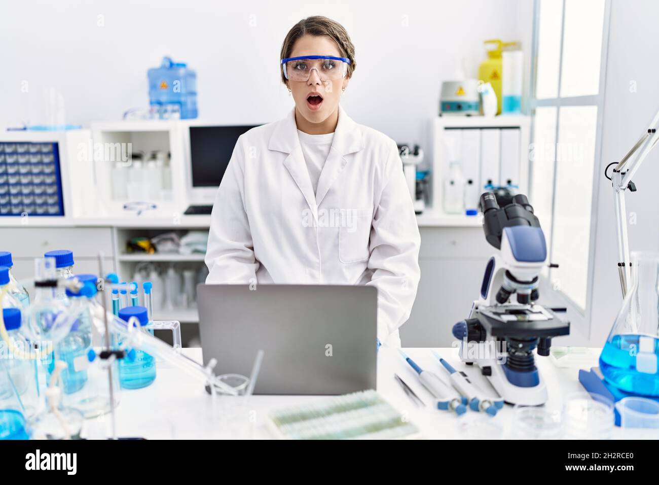 Young hispanic woman wearing scientist uniform working at laboratory ...
