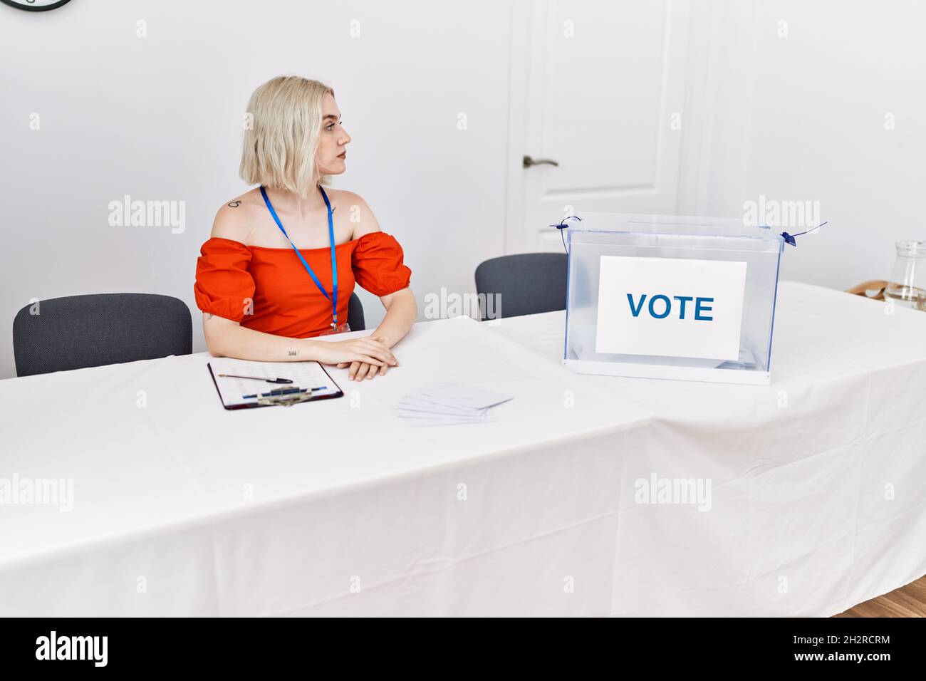 Young caucasian woman at political election sitting by ballot looking ...