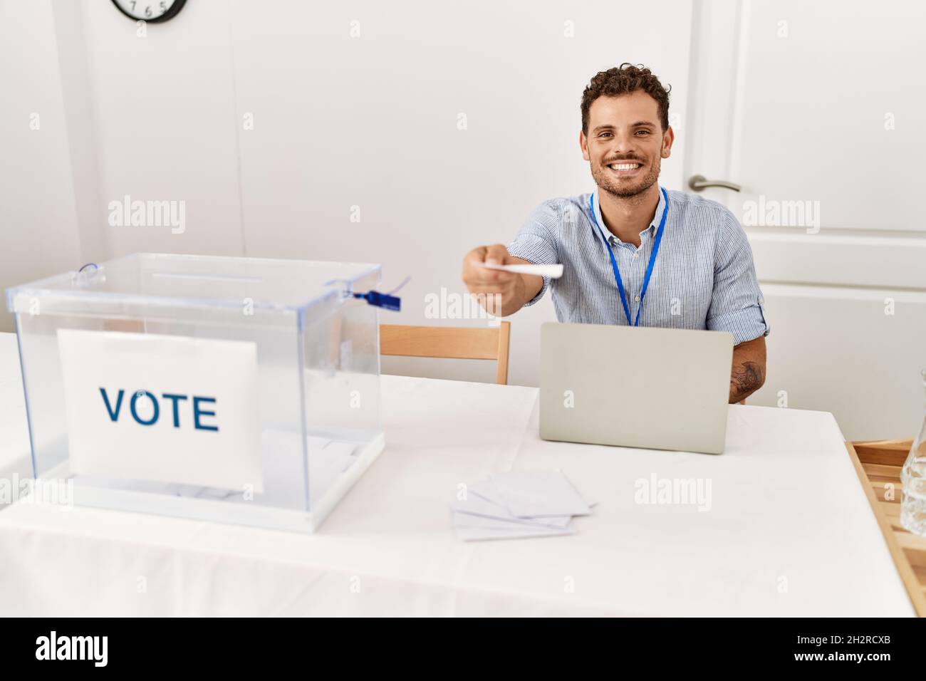 Young hispanic man smiling confident holding vote working at electoral ...