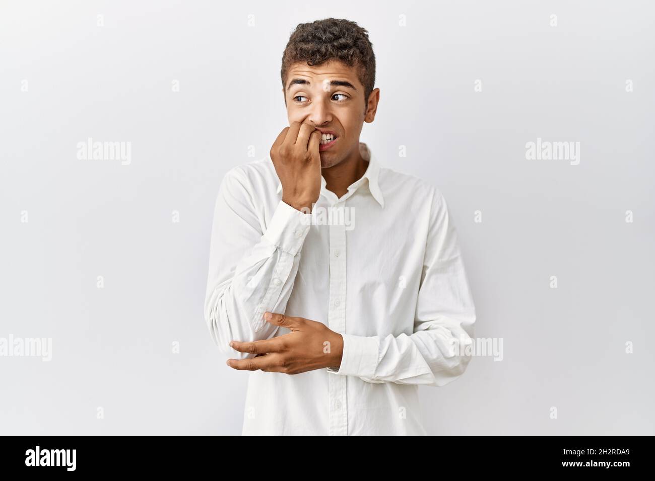 Young handsome hispanic man standing over isolated background looking ...