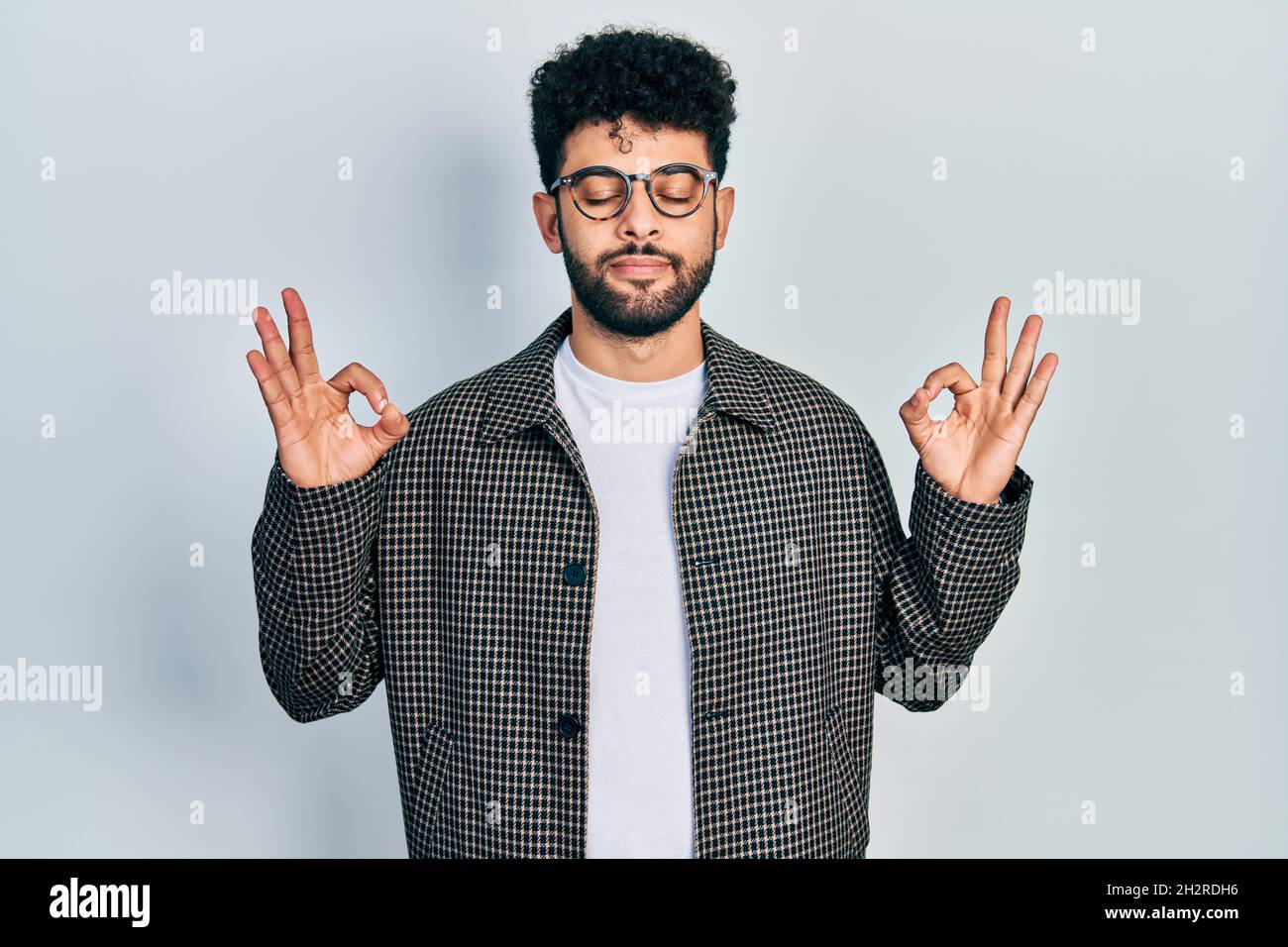 Young arab man with beard wearing glasses relax and smiling with eyes ...