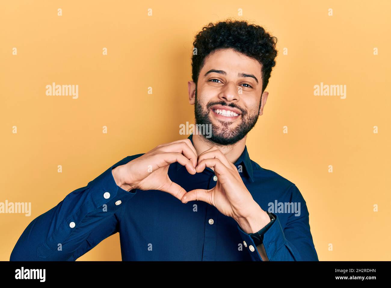 Young arab man with beard wearing casual shirt smiling in love doing ...