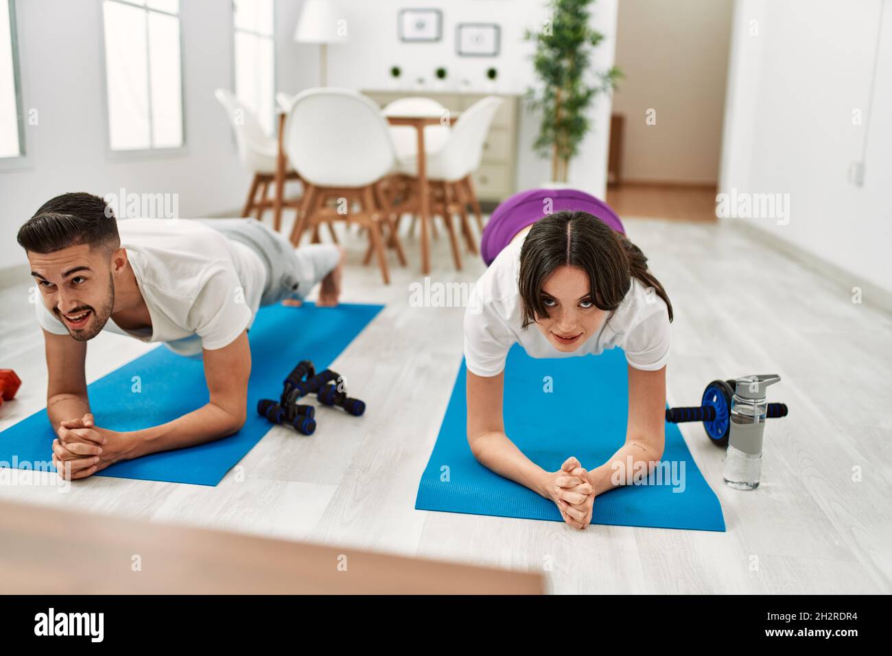 Young hispanic couple doing abs exercise at home Stock Photo - Alamy
