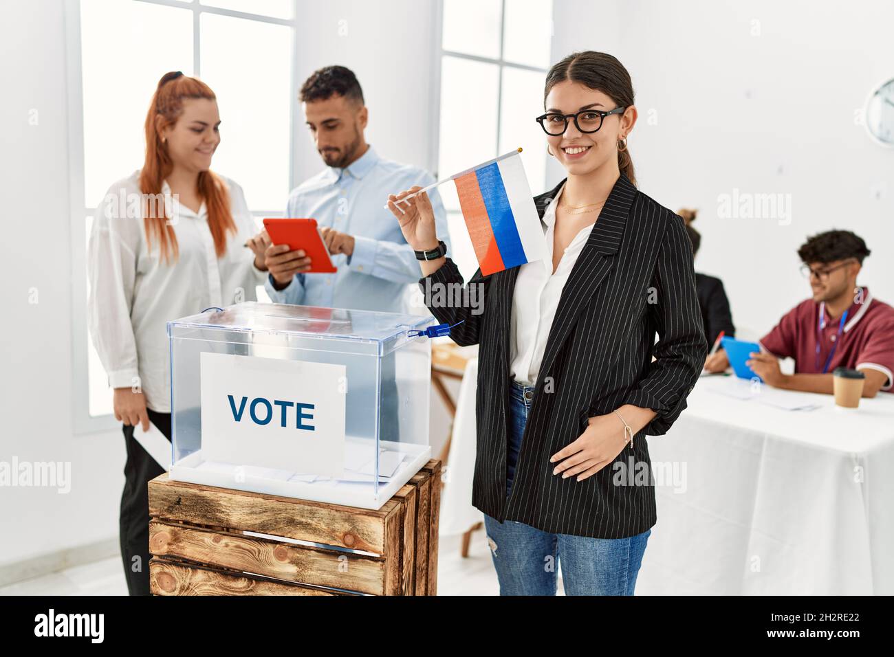 Young russian voter woman smiling happy holding russia flag at vote ...