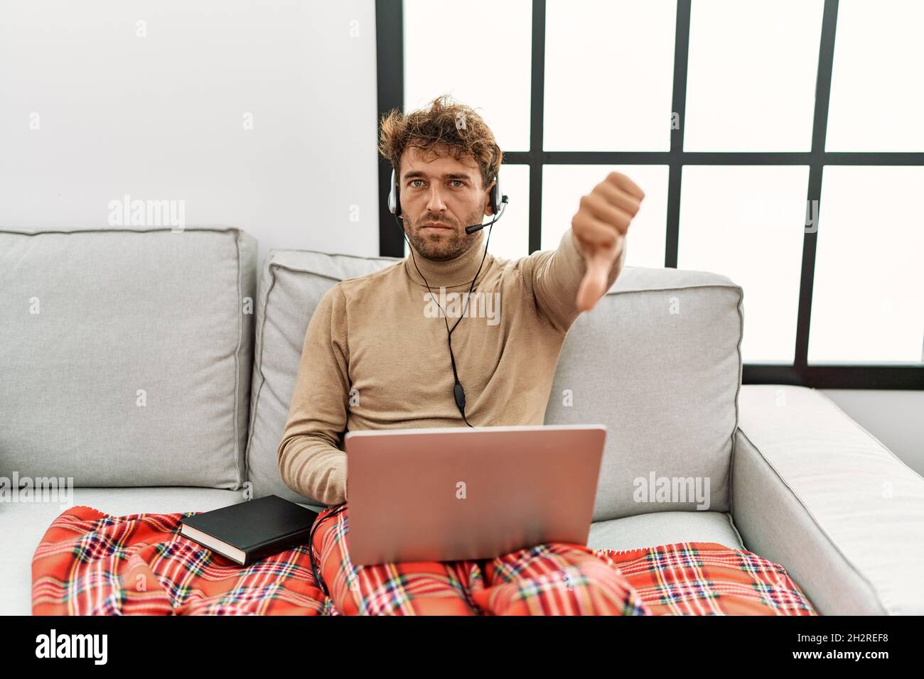 Young handsome man with beard wearing operator headset working from ...