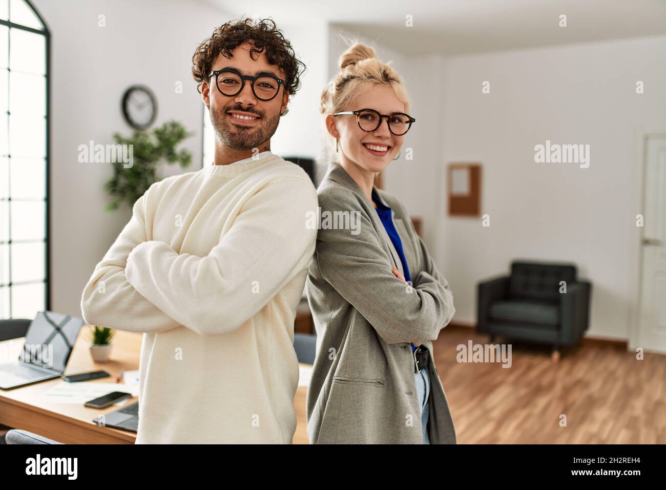 Two business workers smiling happy standing with arms crossed gesture ...