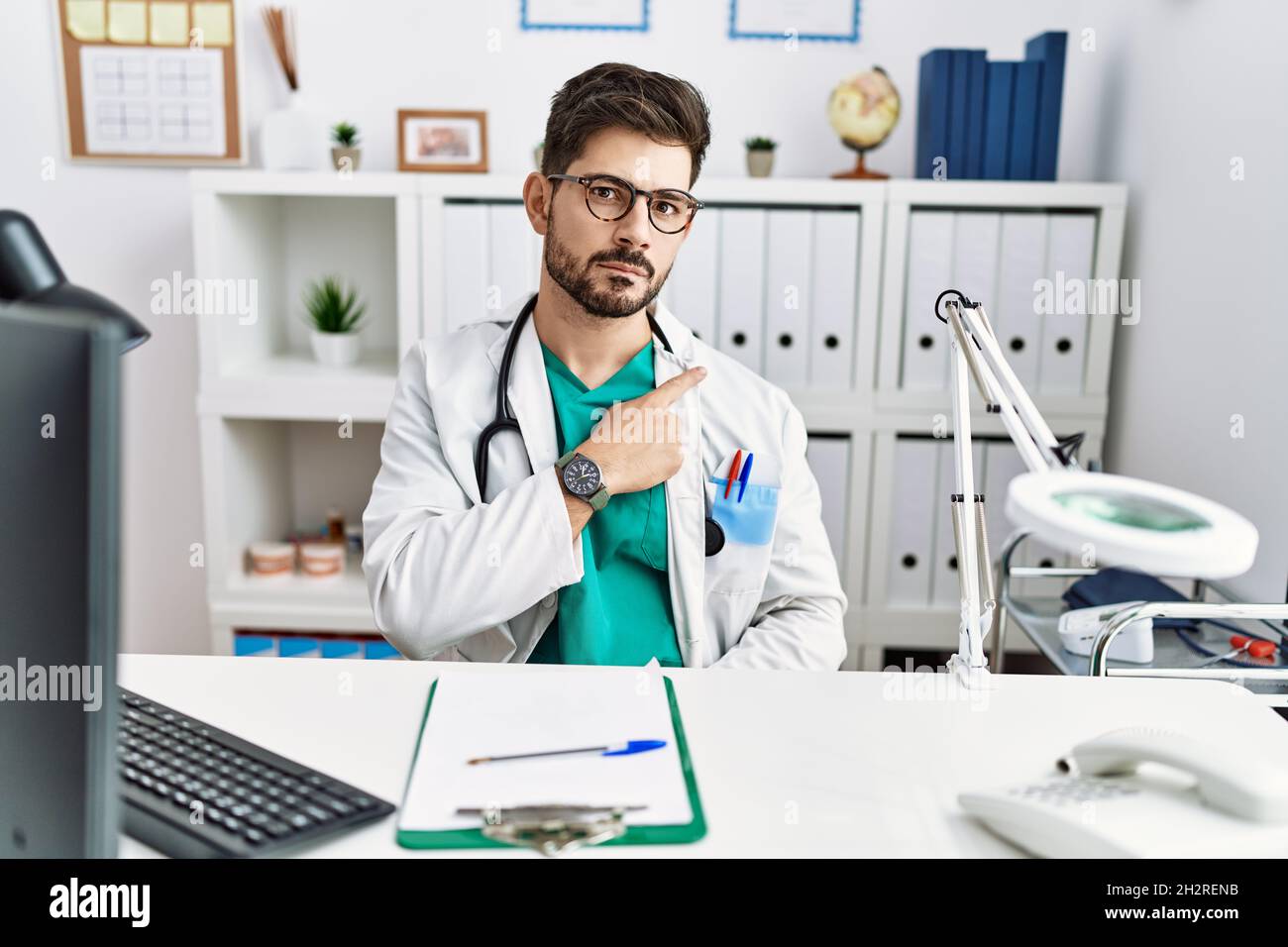 Young man with beard wearing doctor uniform and stethoscope at the ...