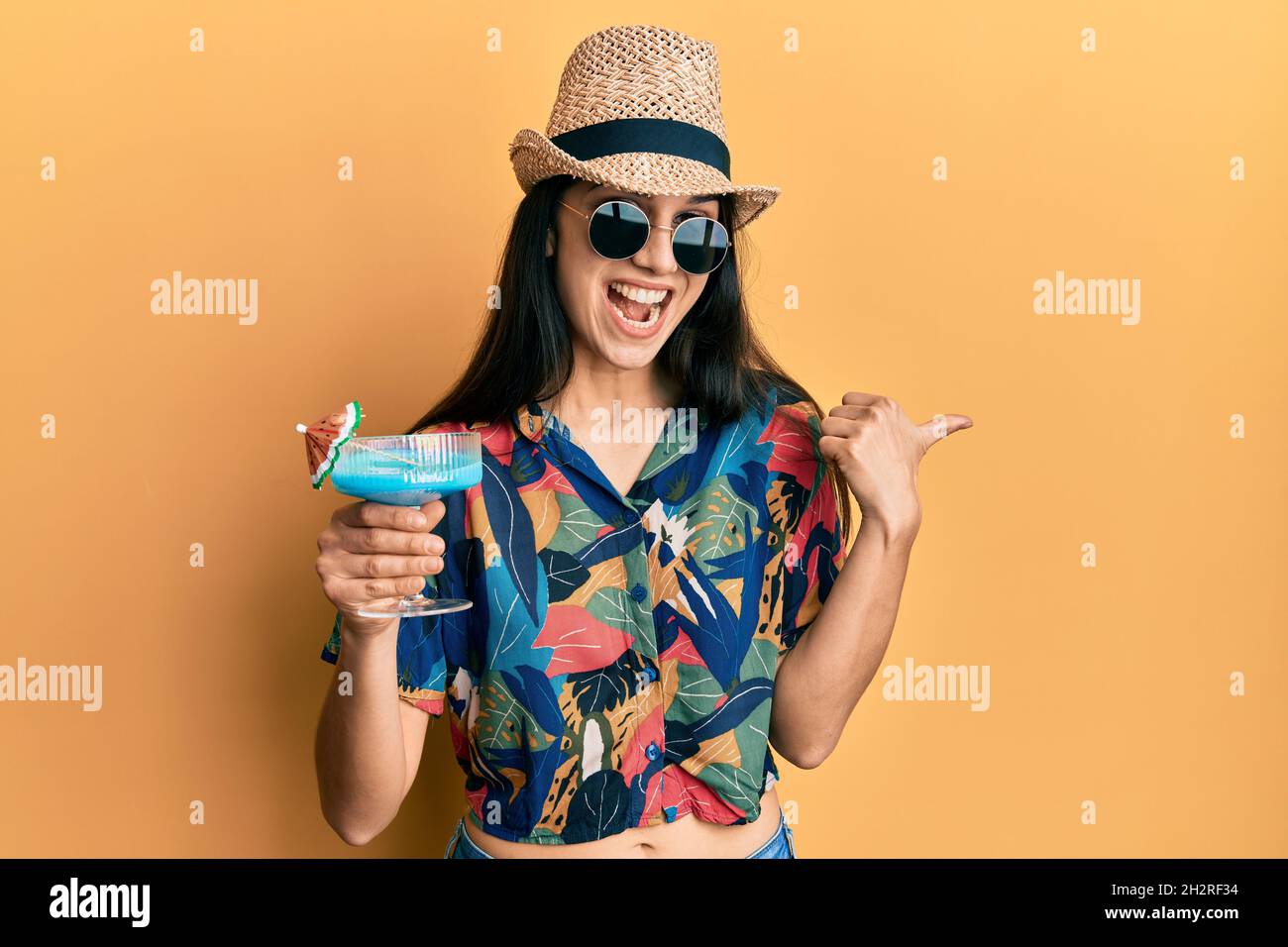 Young hispanic woman wearing summer style drinking tropical cocktail ...