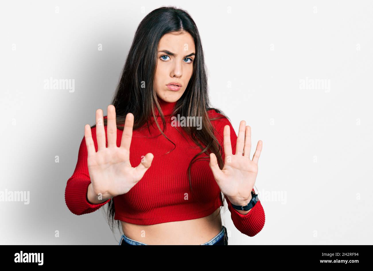 Young brunette teenager wearing red turtleneck sweater moving away ...