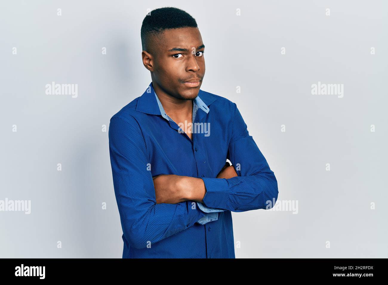 Young african american man with arms crossed gesture skeptic and ...