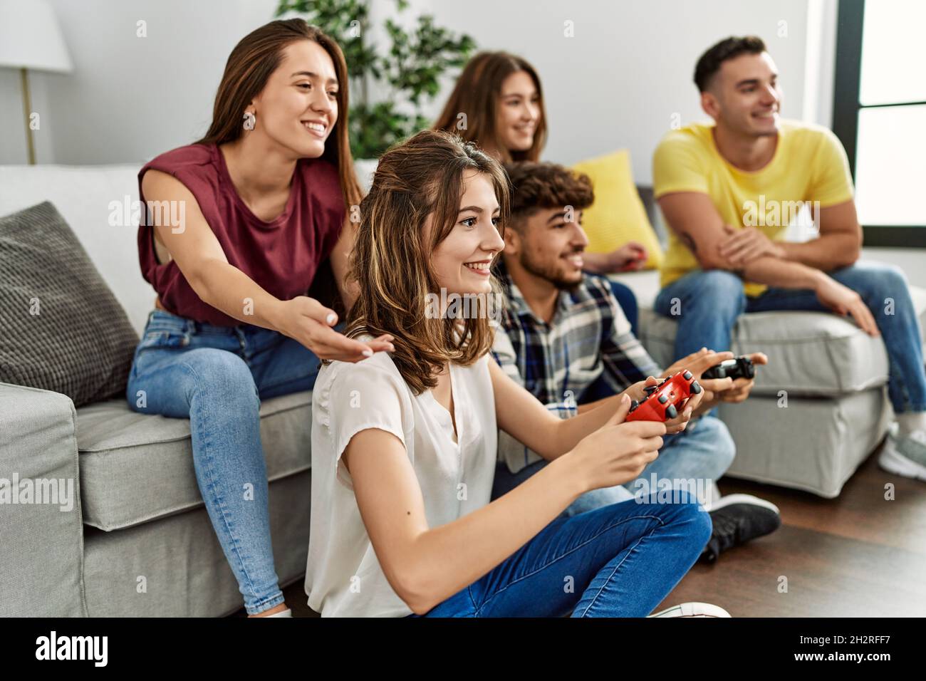 Group of young friends smiling happy playing video game at home Stock ...