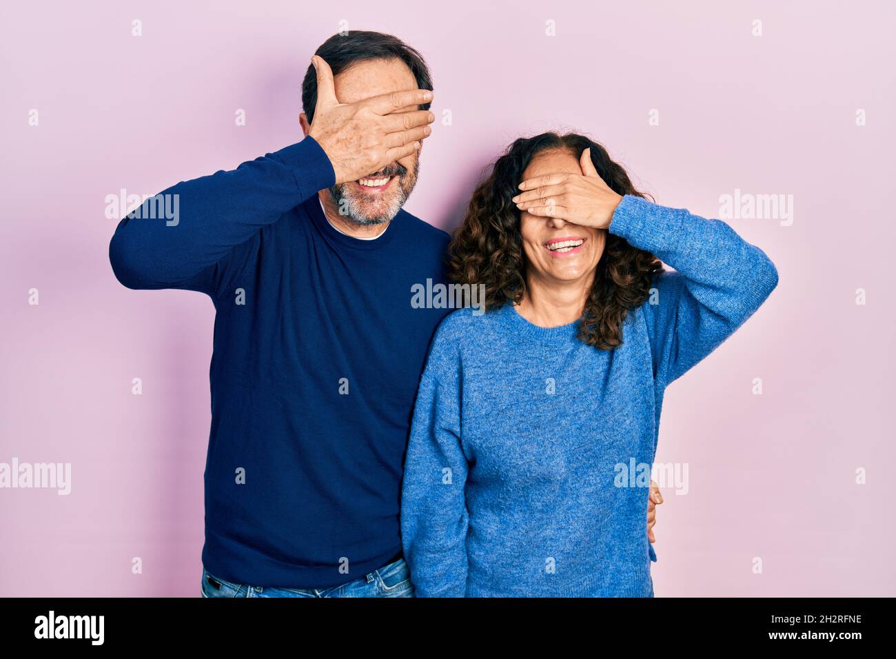 Middle age couple of hispanic woman and man hugging and standing ...