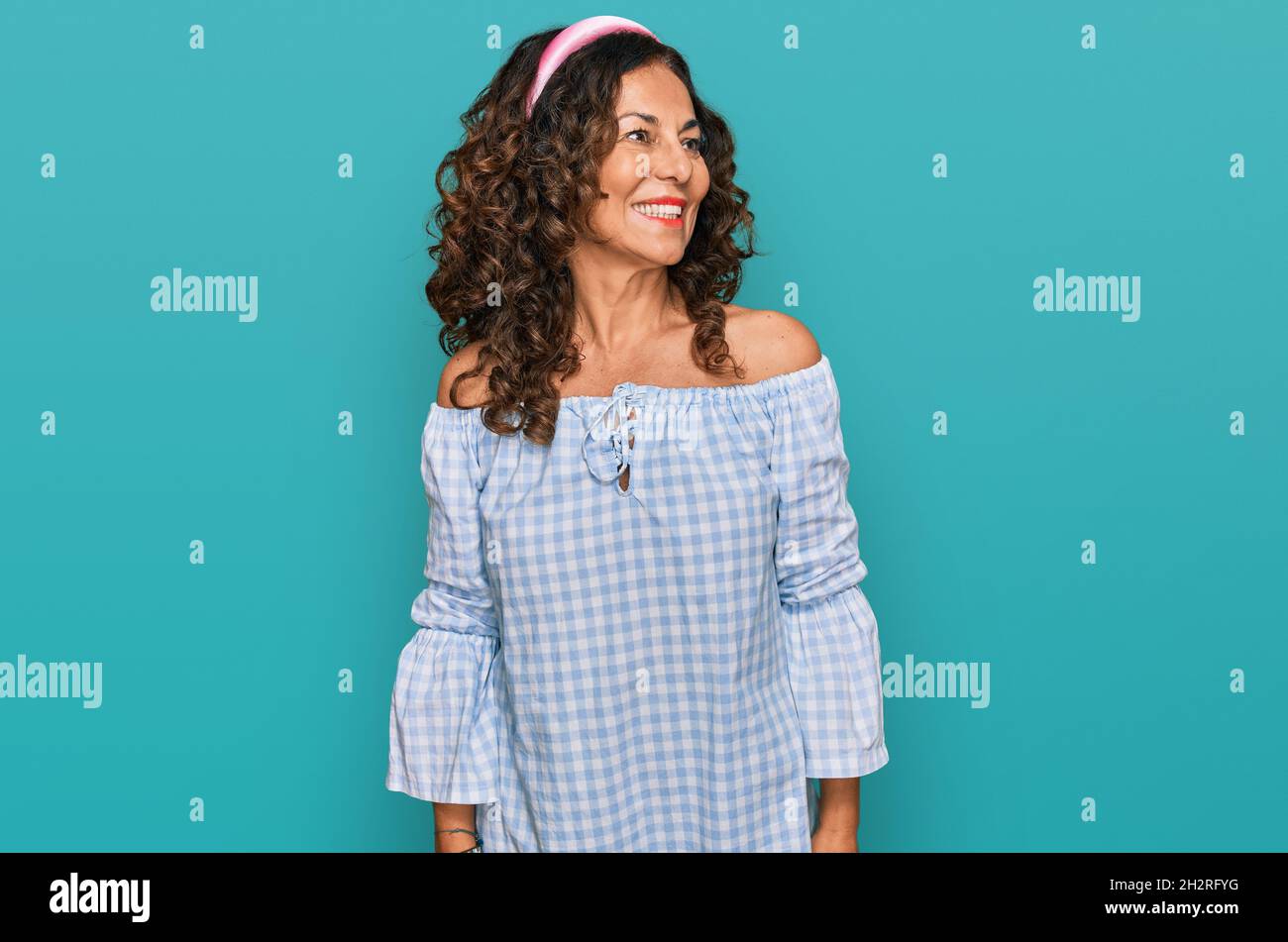 Middle age hispanic woman wearing casual clothes looking away to side ...