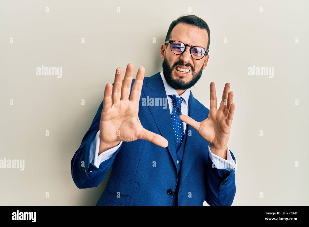 Young man with beard wearing business suit and tie disgusted expression ...