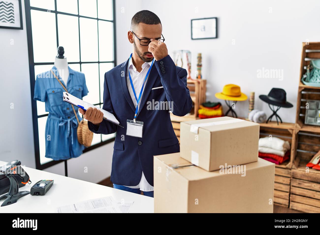 African american man working as manager at retail boutique tired ...