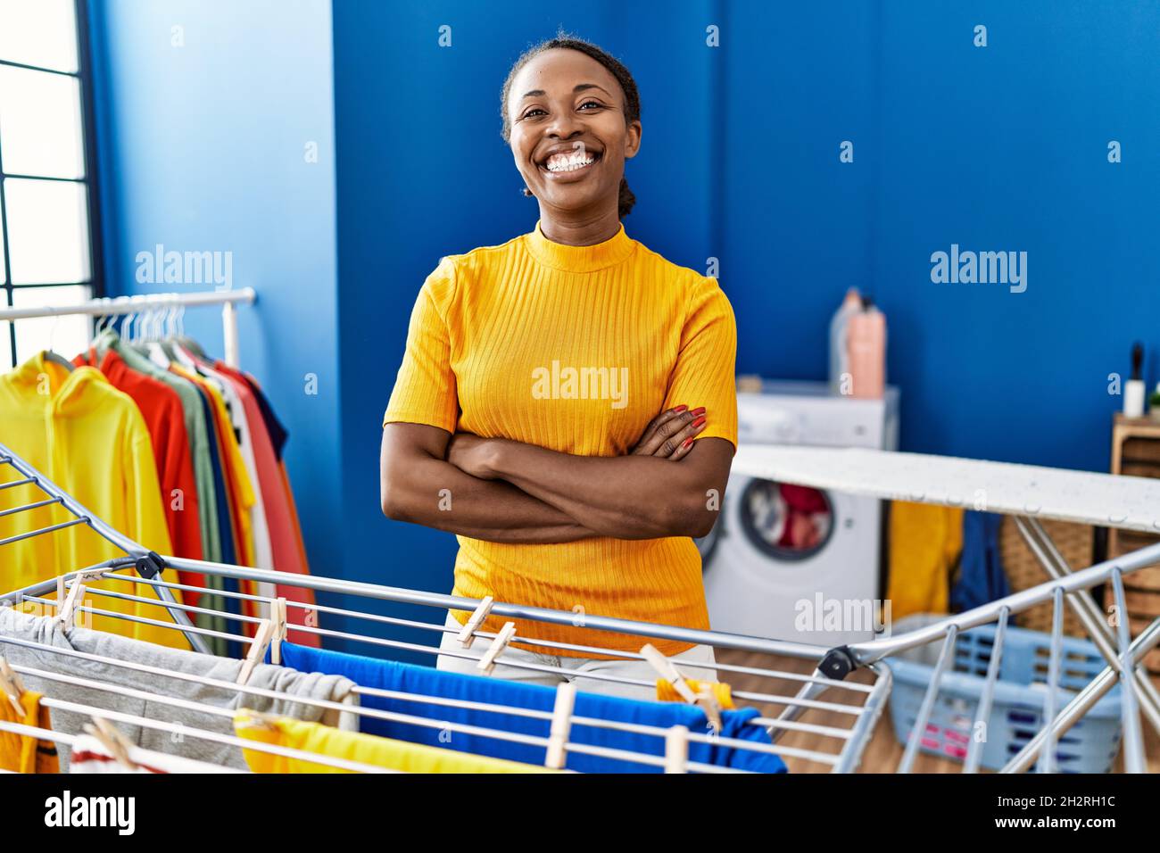 African woman hanging clothes at clothesline happy face smiling with ...