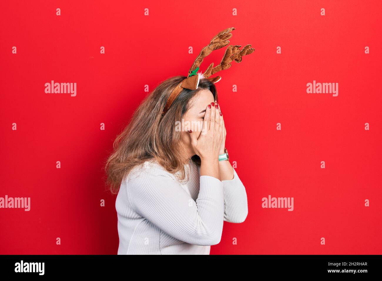 Middle age caucasian woman wearing cute christmas reindeer horns with ...