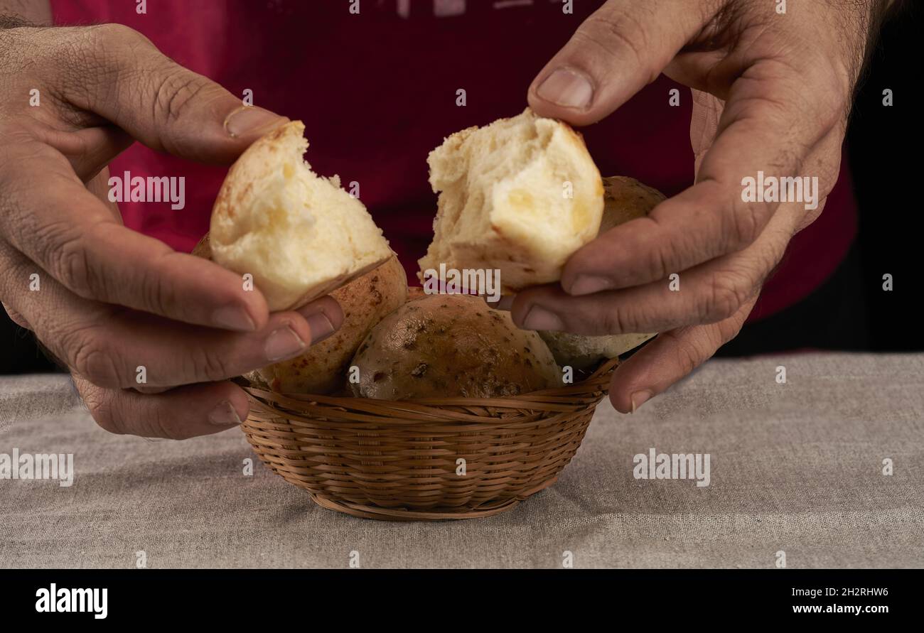 Hand breaking piece of flavored bread Stock Photo - Alamy