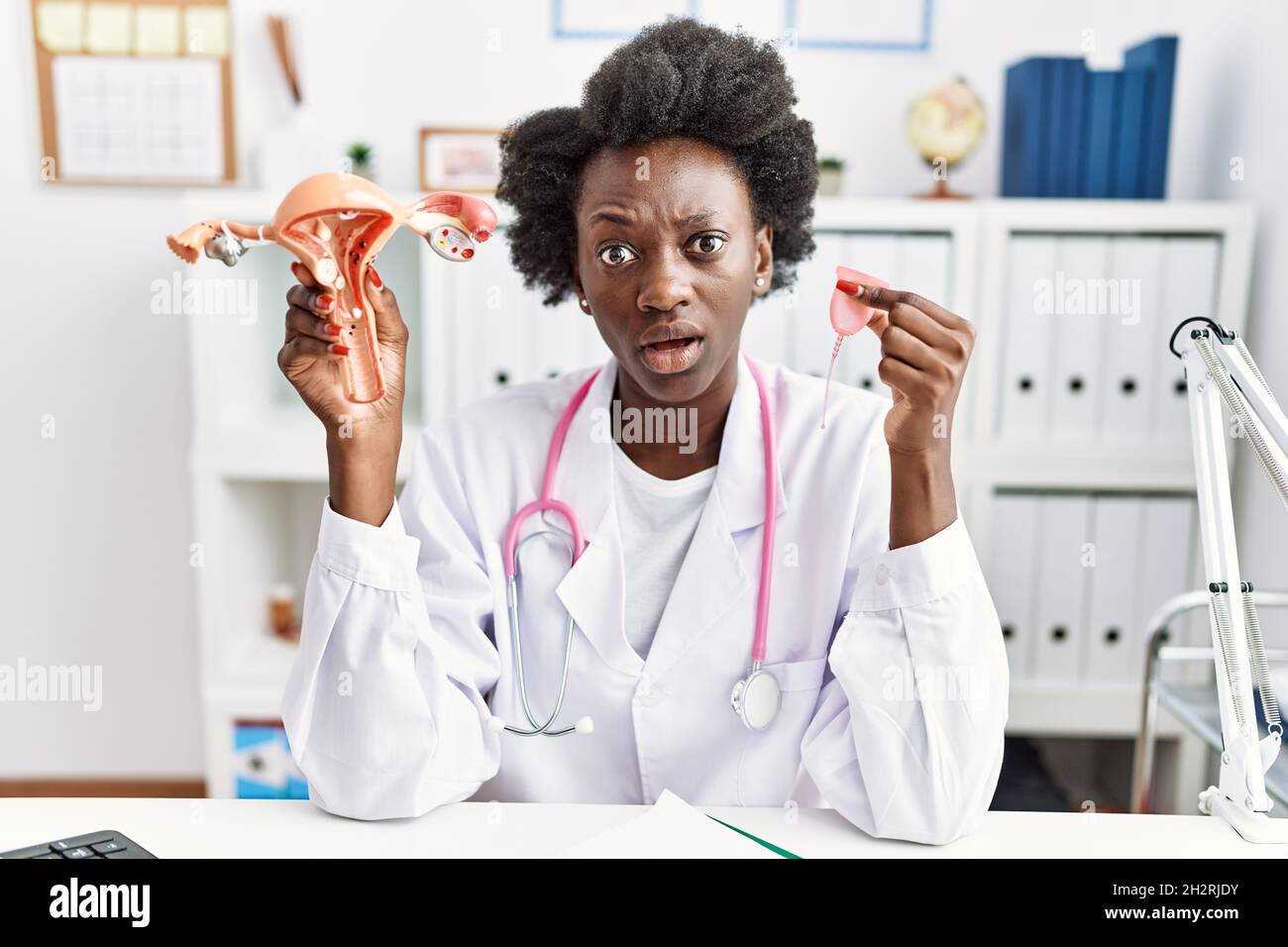 African doctor woman holding anatomical female genital organ and ...