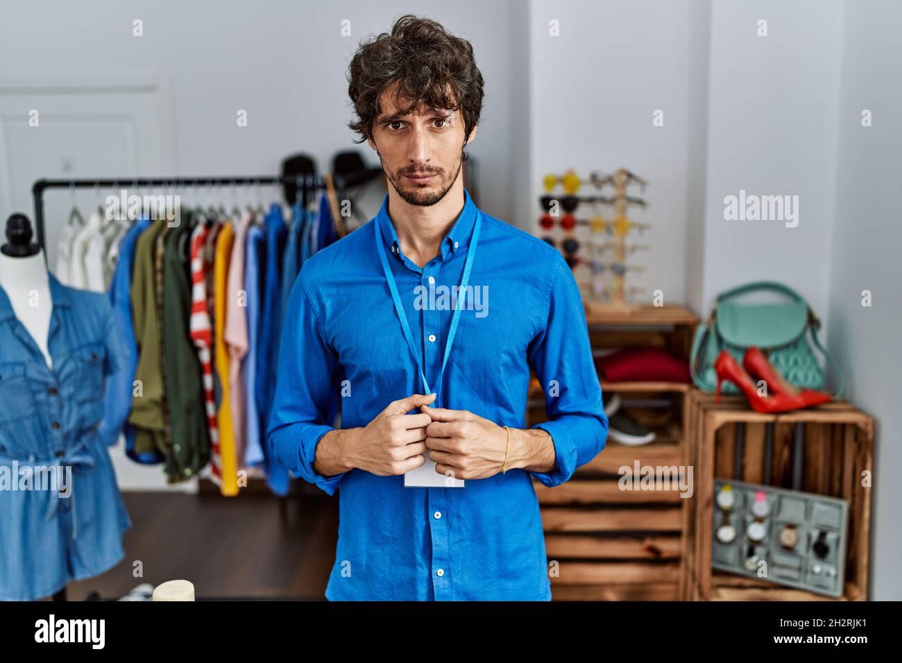 Young hispanic man working as manager at retail boutique depressed and ...
