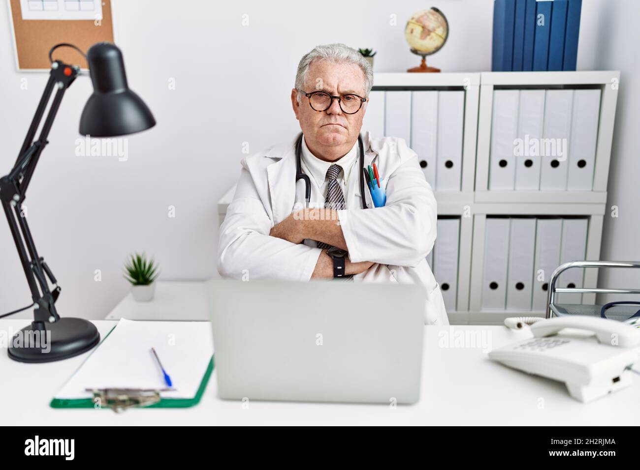 Senior caucasian man wearing doctor uniform and stethoscope at the ...