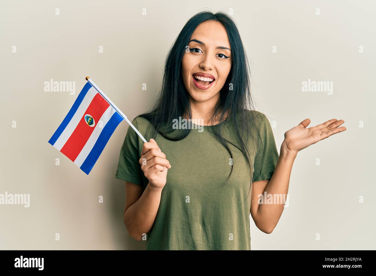 Young hispanic girl holding costa rica flag celebrating achievement ...