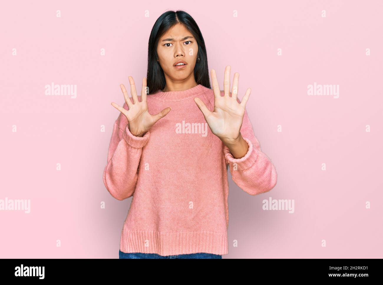 Beautiful young asian woman wearing casual winter sweater afraid and ...