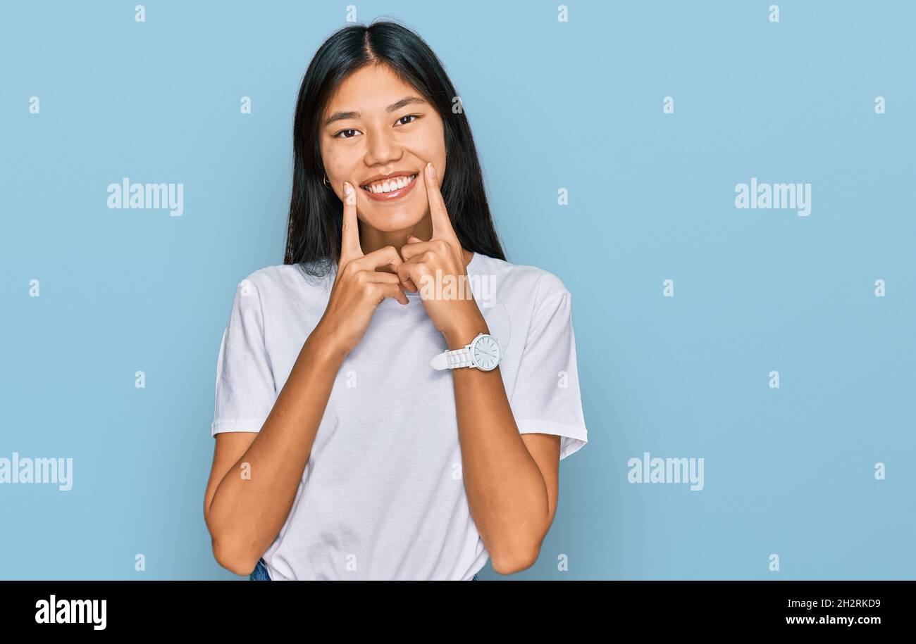 Beautiful young asian woman wearing casual white t shirt smiling with ...