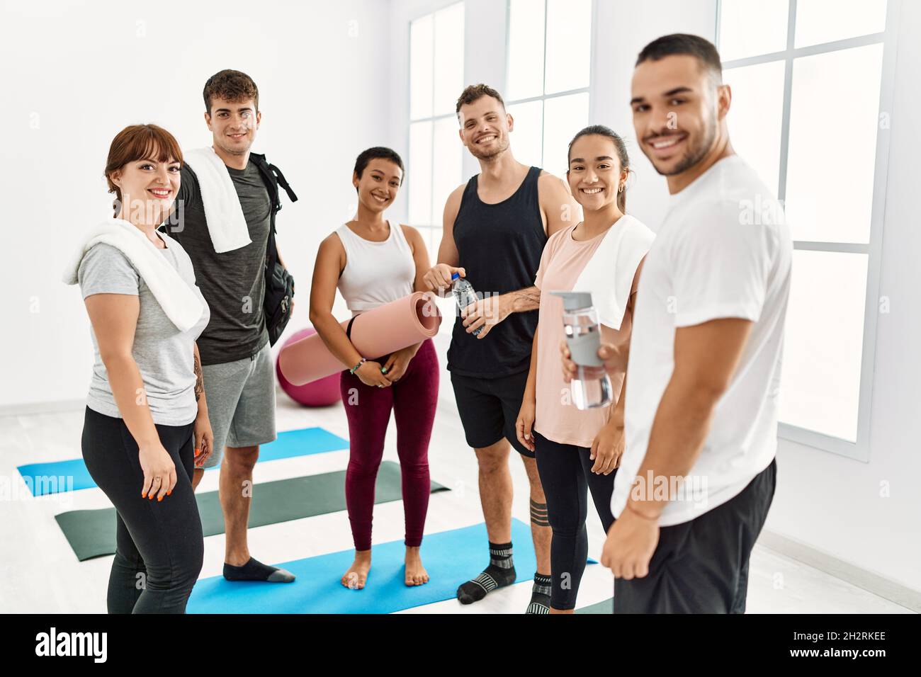 Group of young sporty people smiling happy and looking to the camera at ...