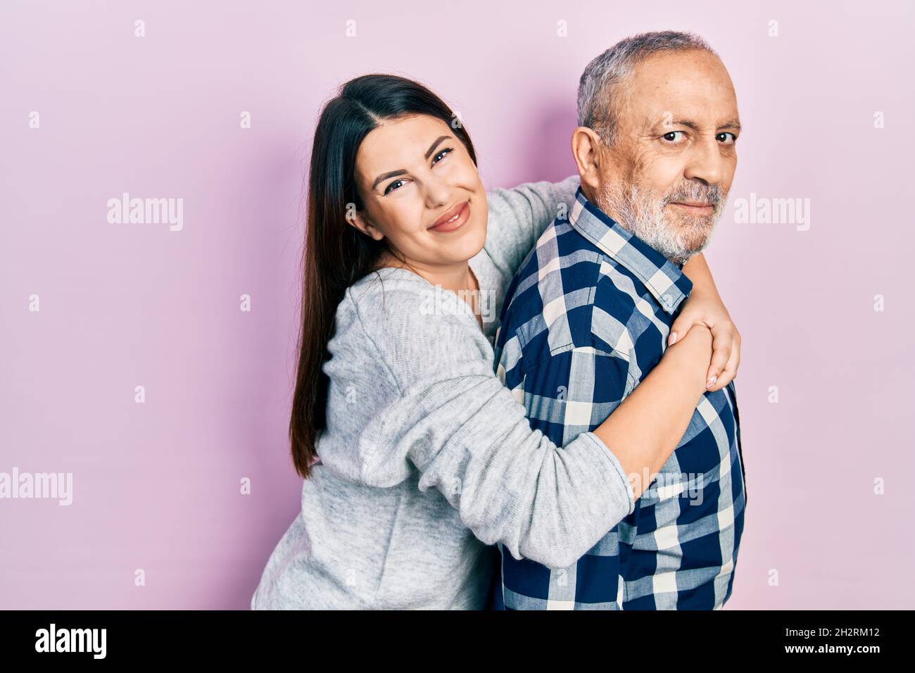 Hispanic father and daughter wearing casual clothes looking to side ...
