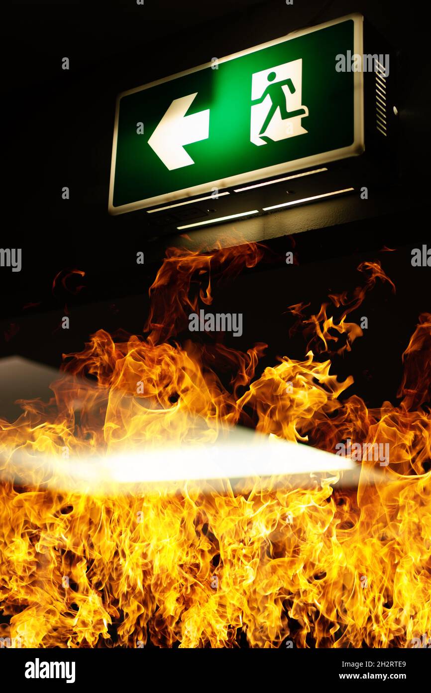 Green fire escape sign hang on the ceiling in the Warehouse. The ...